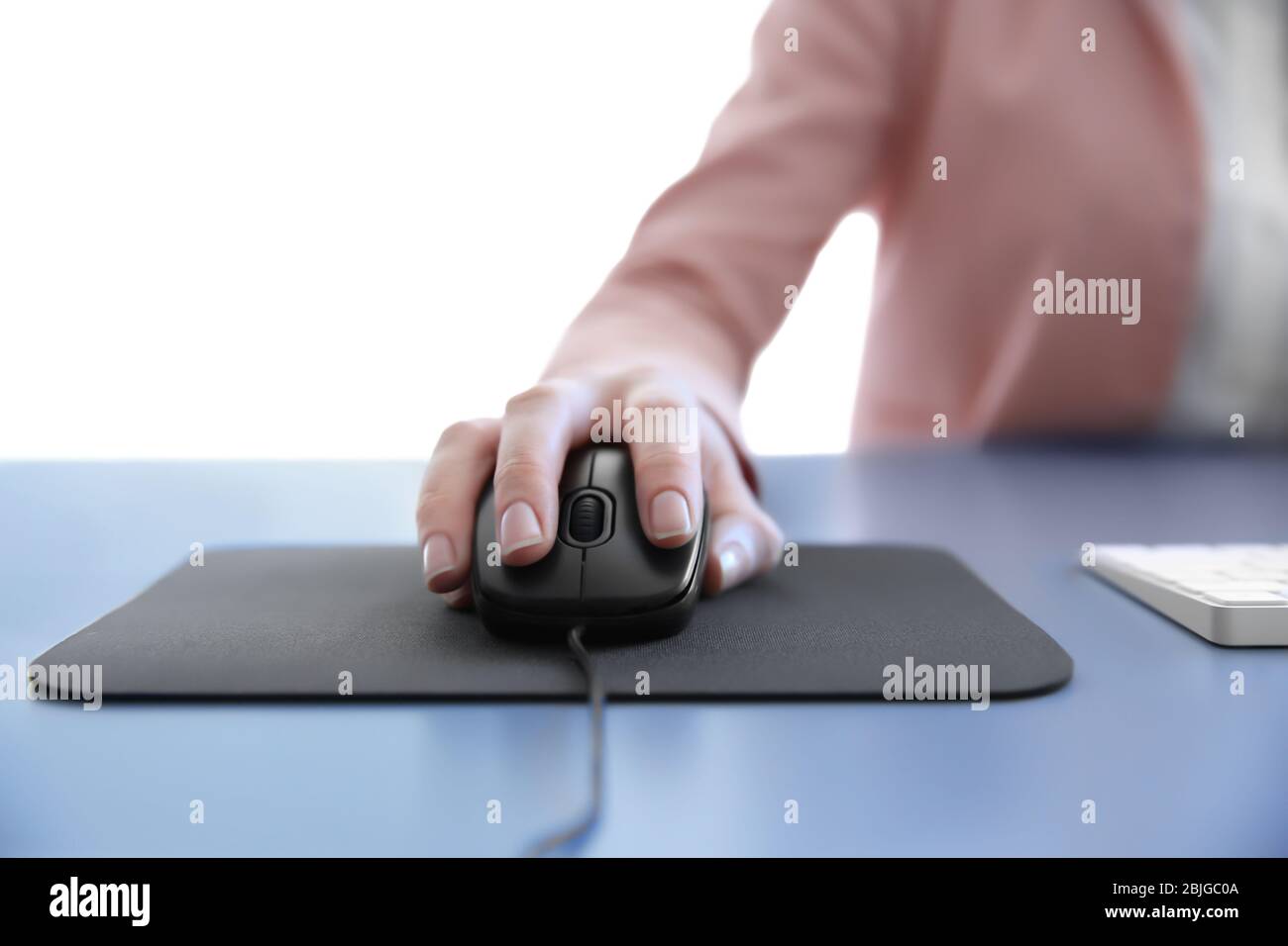 Female hand holding computer mouse on pad Stock Photo - Alamy
