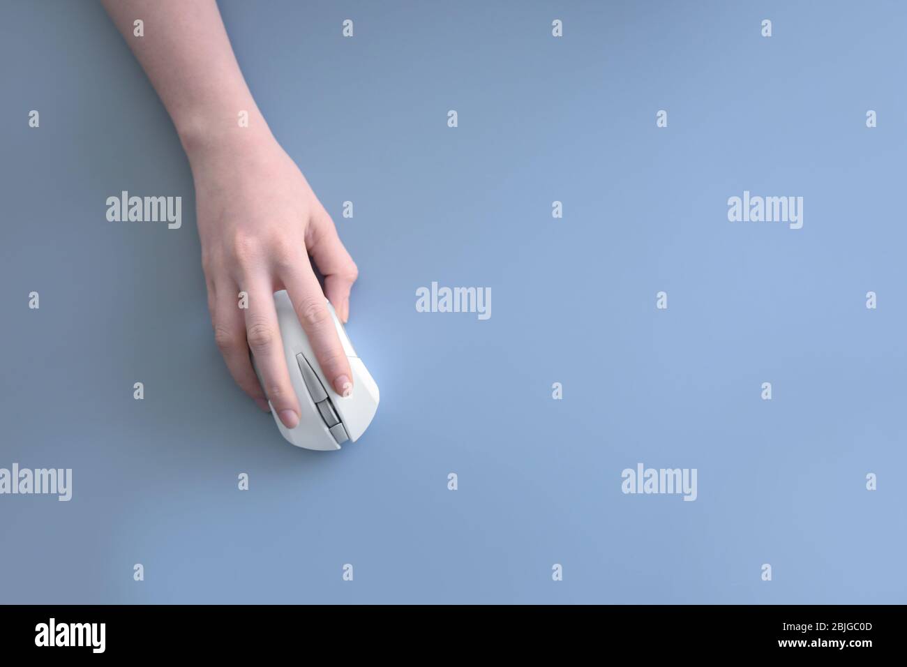 Female hand holding computer mouse on grey background Stock Photo - Alamy