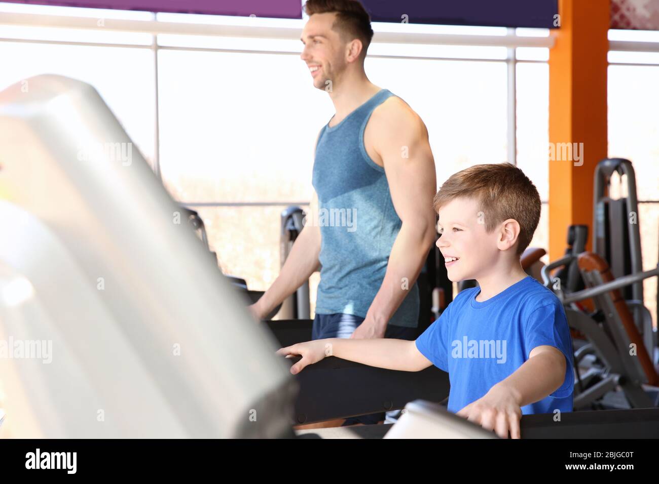 Dad training son on treadmill in gym Stock Photo - Alamy