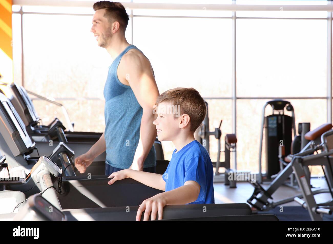 Dad training son on treadmill in gym Stock Photo - Alamy