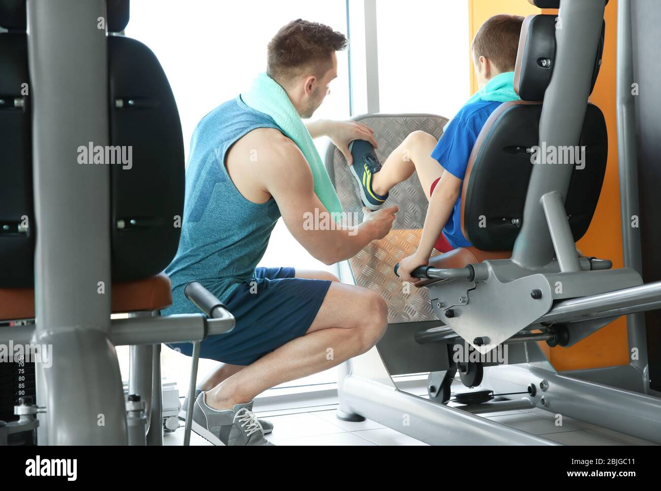 Dad and son doing exercises in gym Stock Photo - Alamy