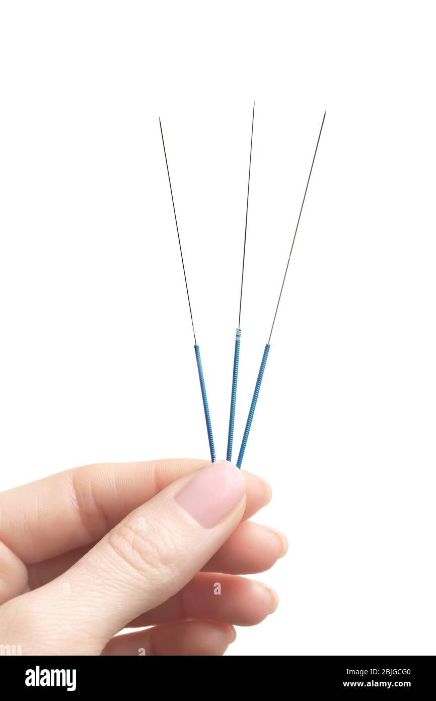 Female hand with needles for acupuncture on white background, closeup ...