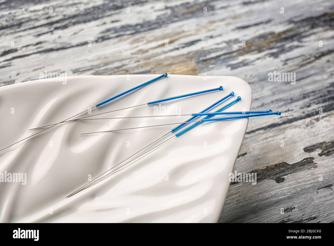 Special stand with needles for acupuncture on wooden background ...