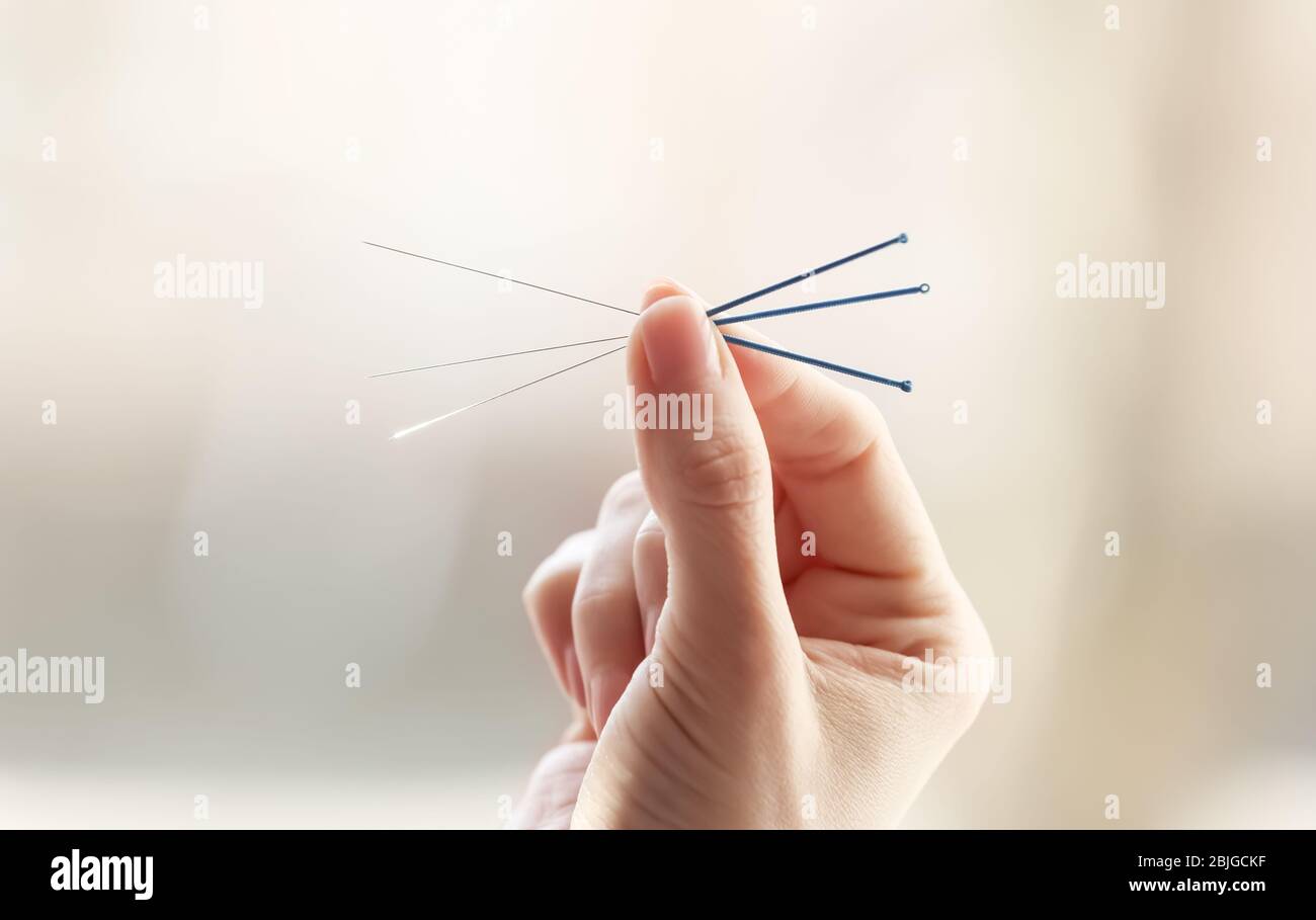 Female hand with needles for acupuncture on blurred background Stock ...