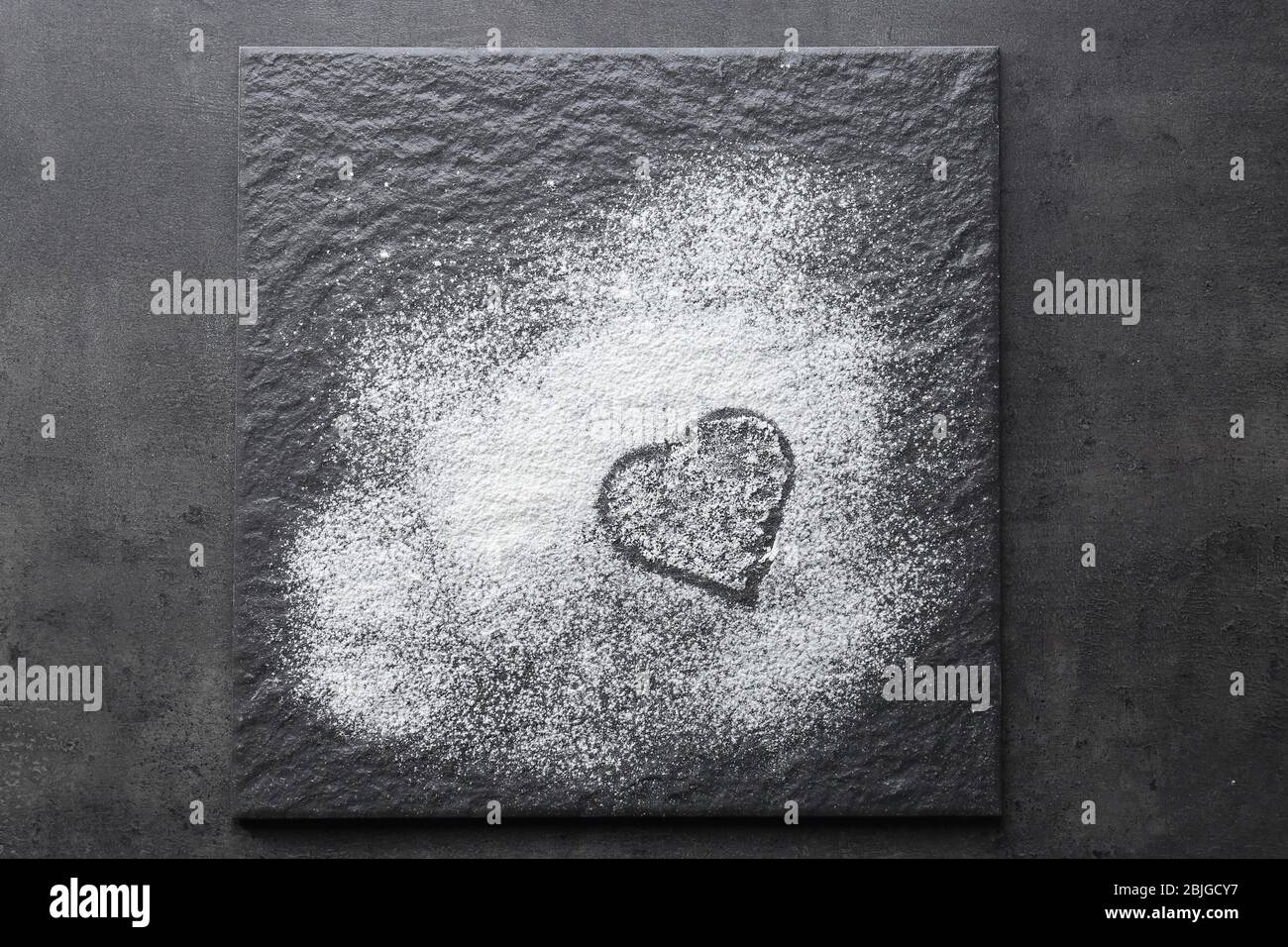 Slate plate with heart made of flour on dark background Stock Photo - Alamy