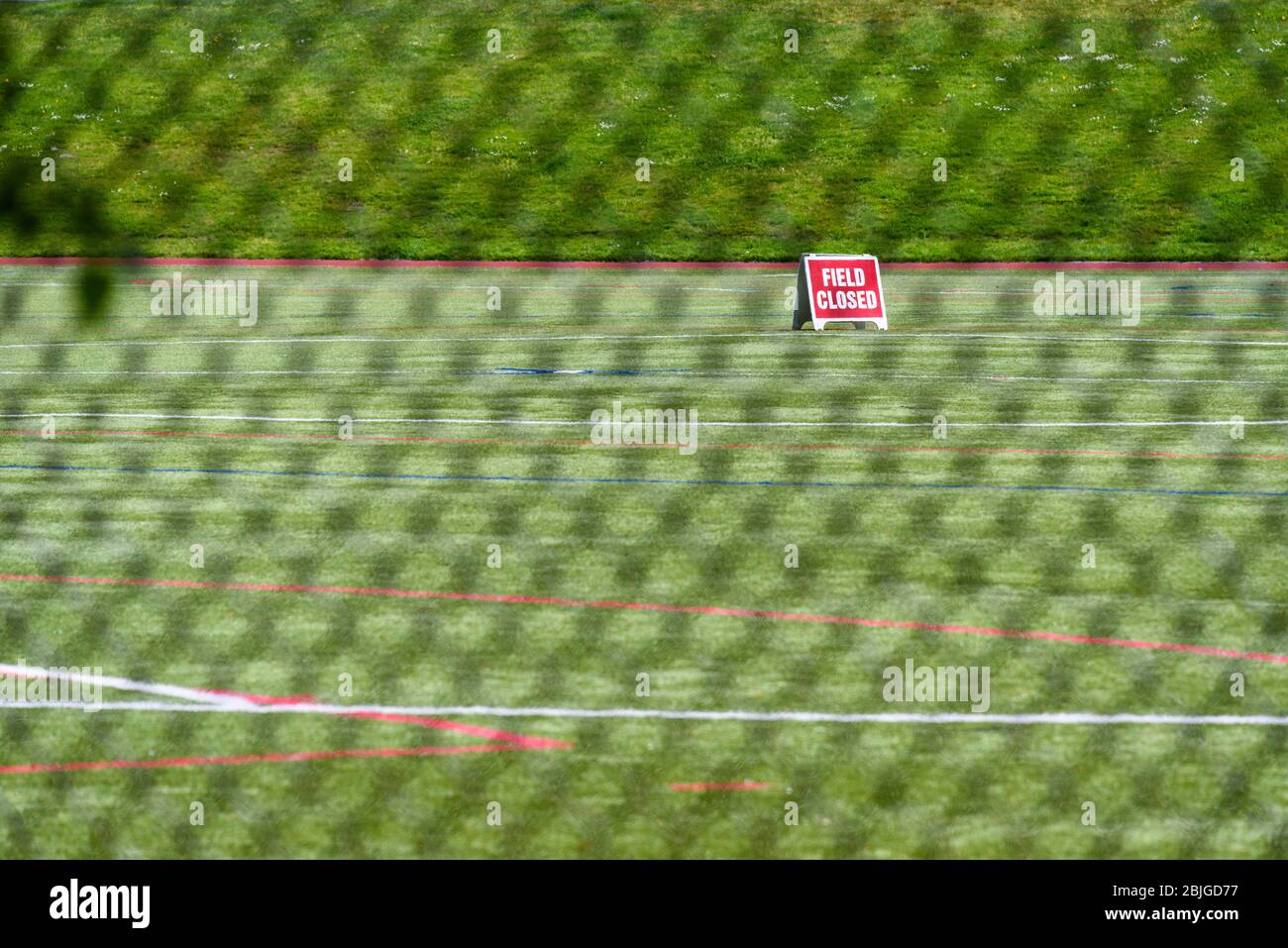 Field closed sign behind chain link fence, athletic field closed due to ...