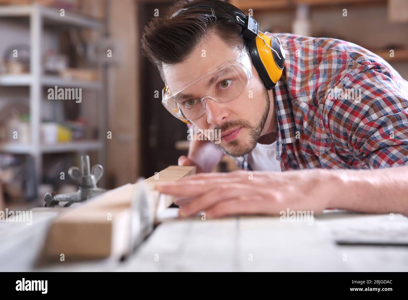 Carpenter checking width of timber after sawing in workshop Stock Photo ...