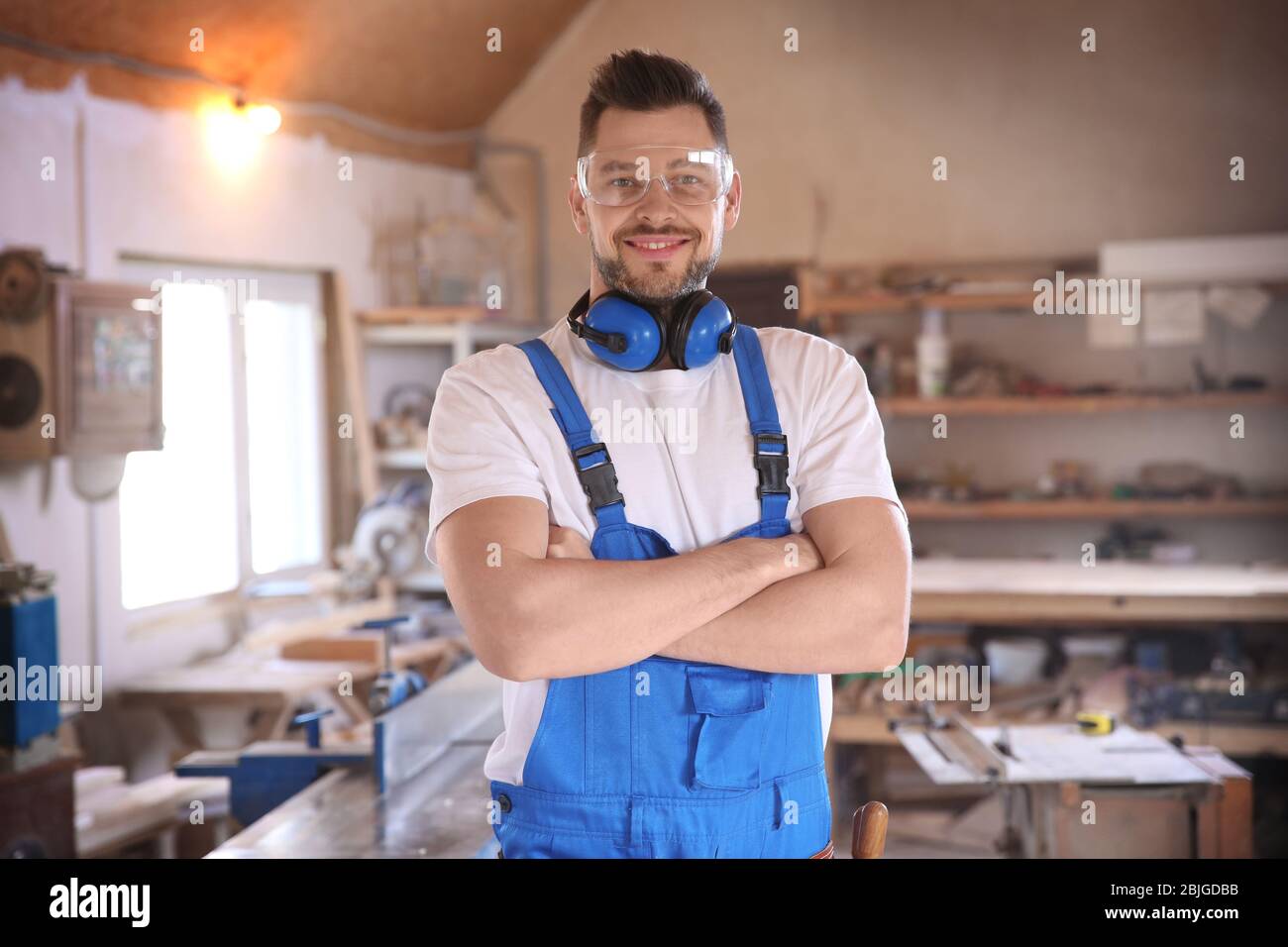 Young carpenter wearing uniform in workshop Stock Photo - Alamy