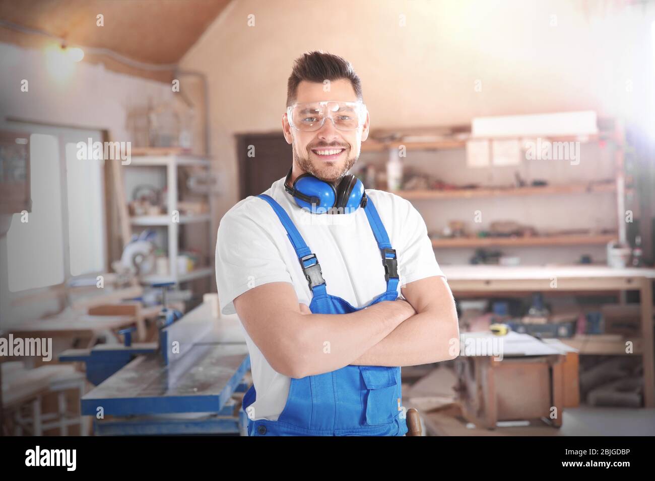 Young carpenter wearing uniform in workshop Stock Photo - Alamy