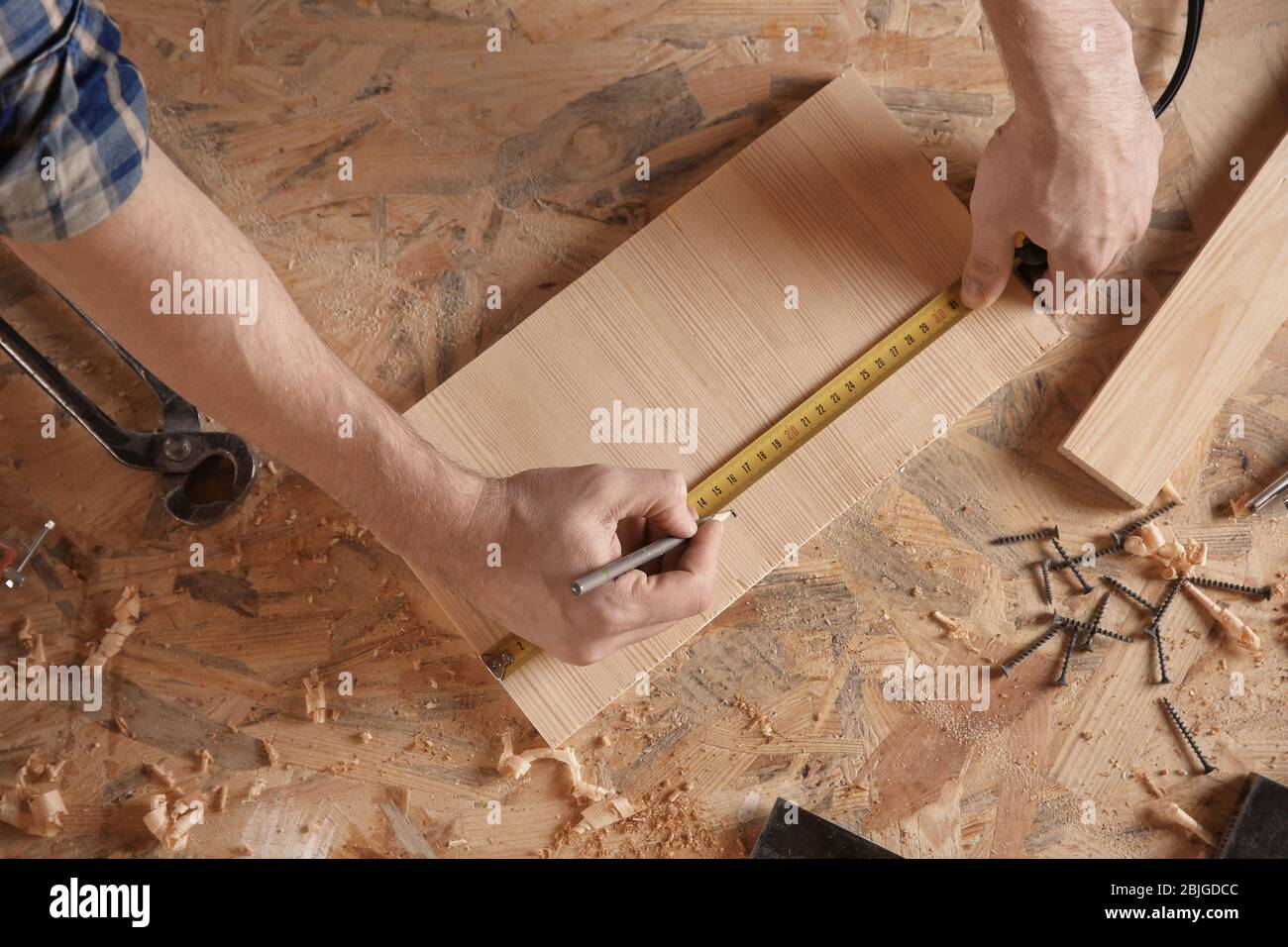 Carpenter marking measurements on piece of wooden board Stock Photo - Alamy
