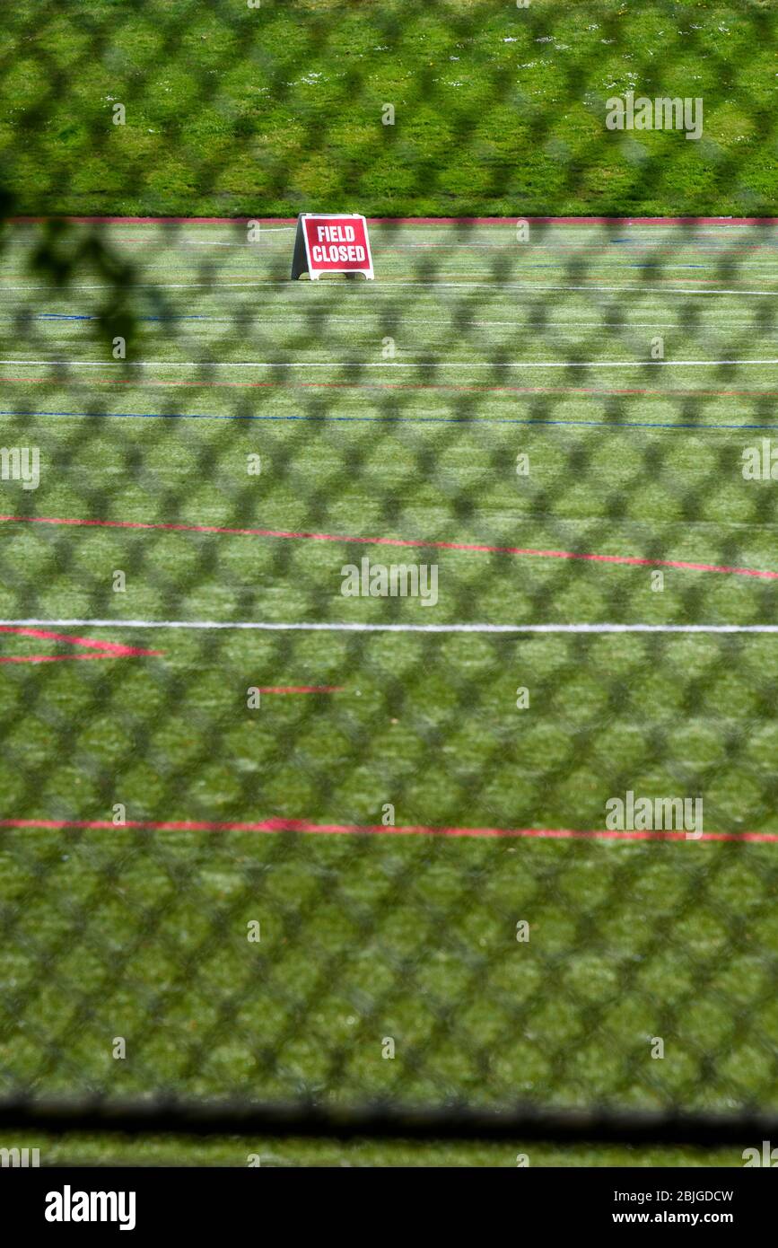 Field closed sign behind chain link fence, athletic field closed due to ...