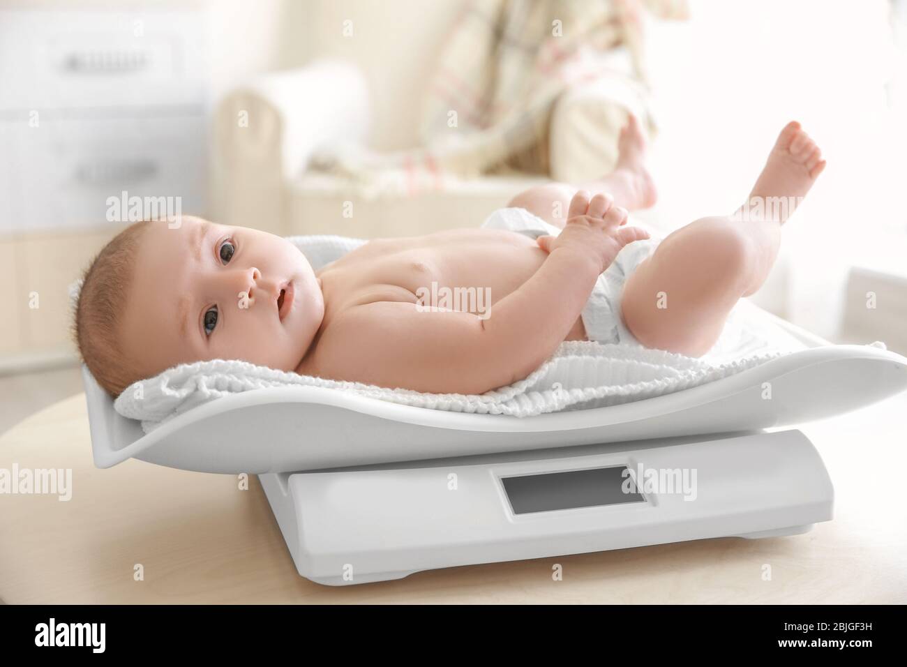 Cute little baby lying on scales at home Stock Photo - Alamy