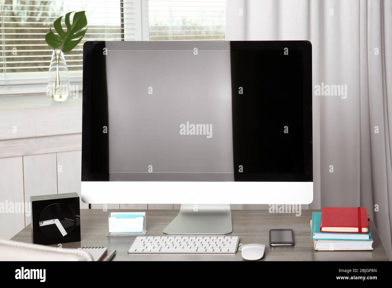 Comfortable workplace with modern monitor and blinds on window Stock ...