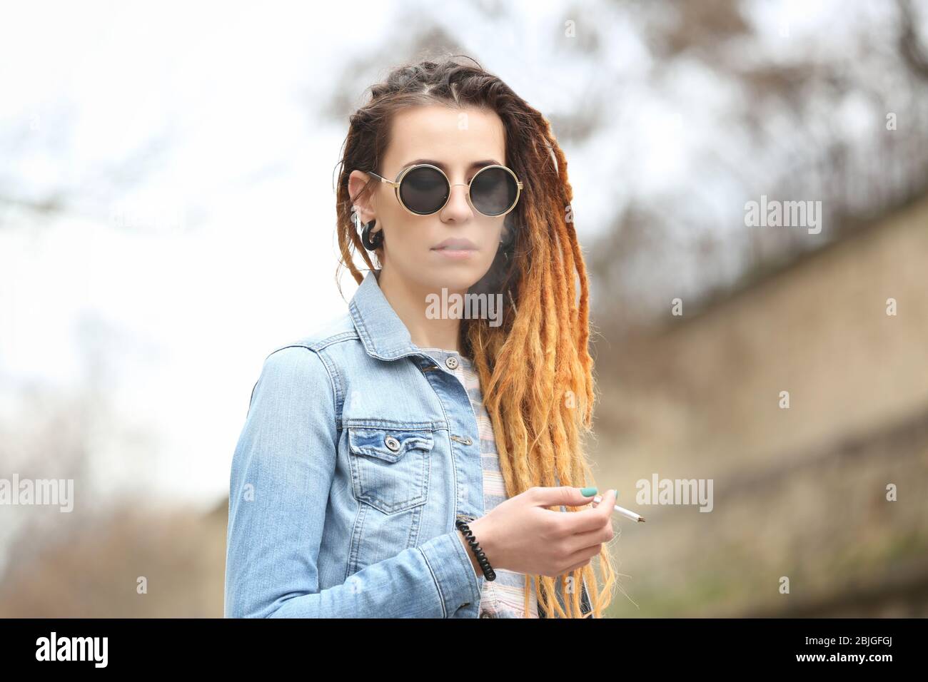 Young beautiful woman smoking weed on blurred background Stock Photo ...