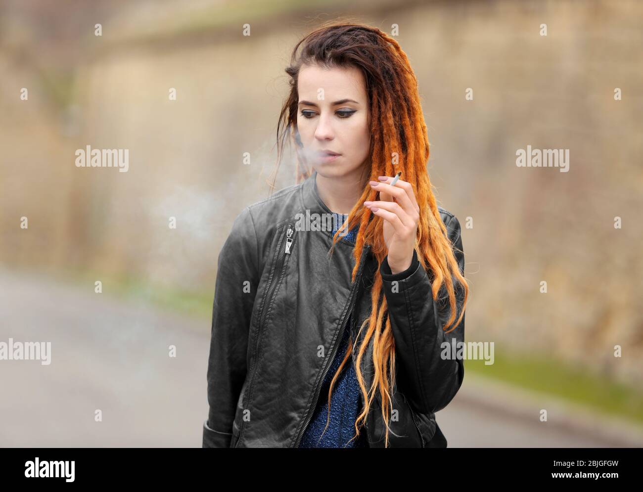 Young beautiful woman smoking weed on blurred background Stock Photo ...