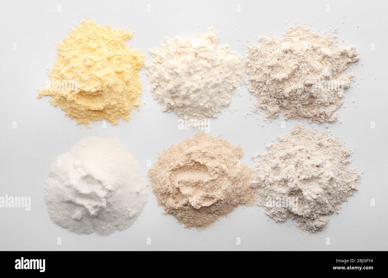 Different types of flour on white background Stock Photo - Alamy