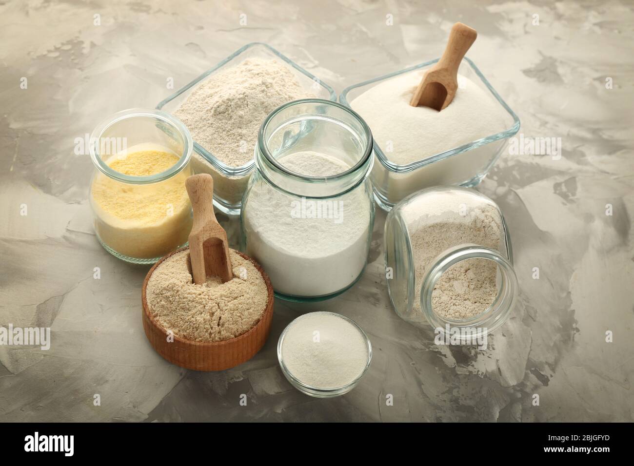 Composition with different types of flour on grey textured background ...