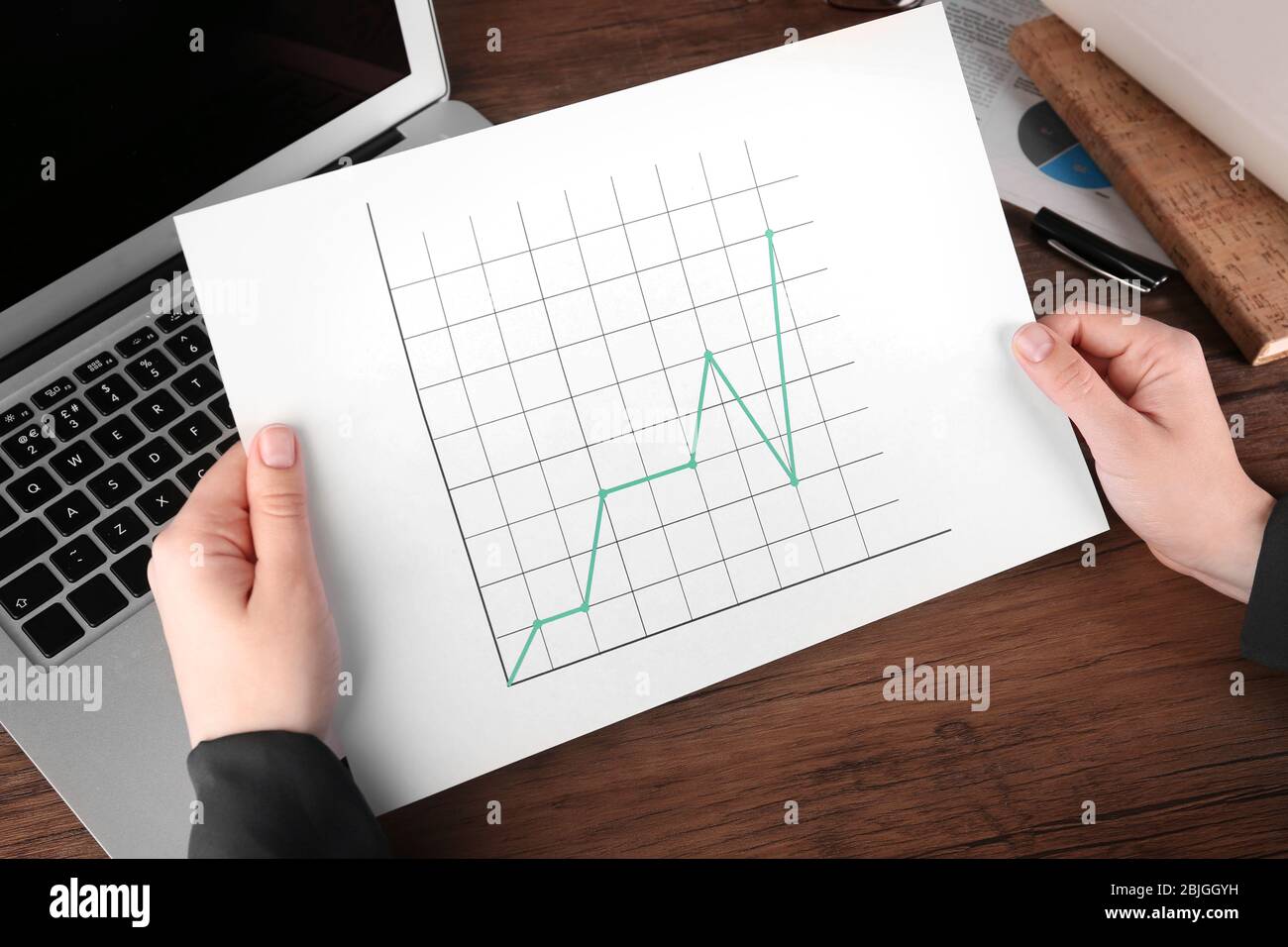 Woman holding paper sheet with diagram at table. Marketing concept ...