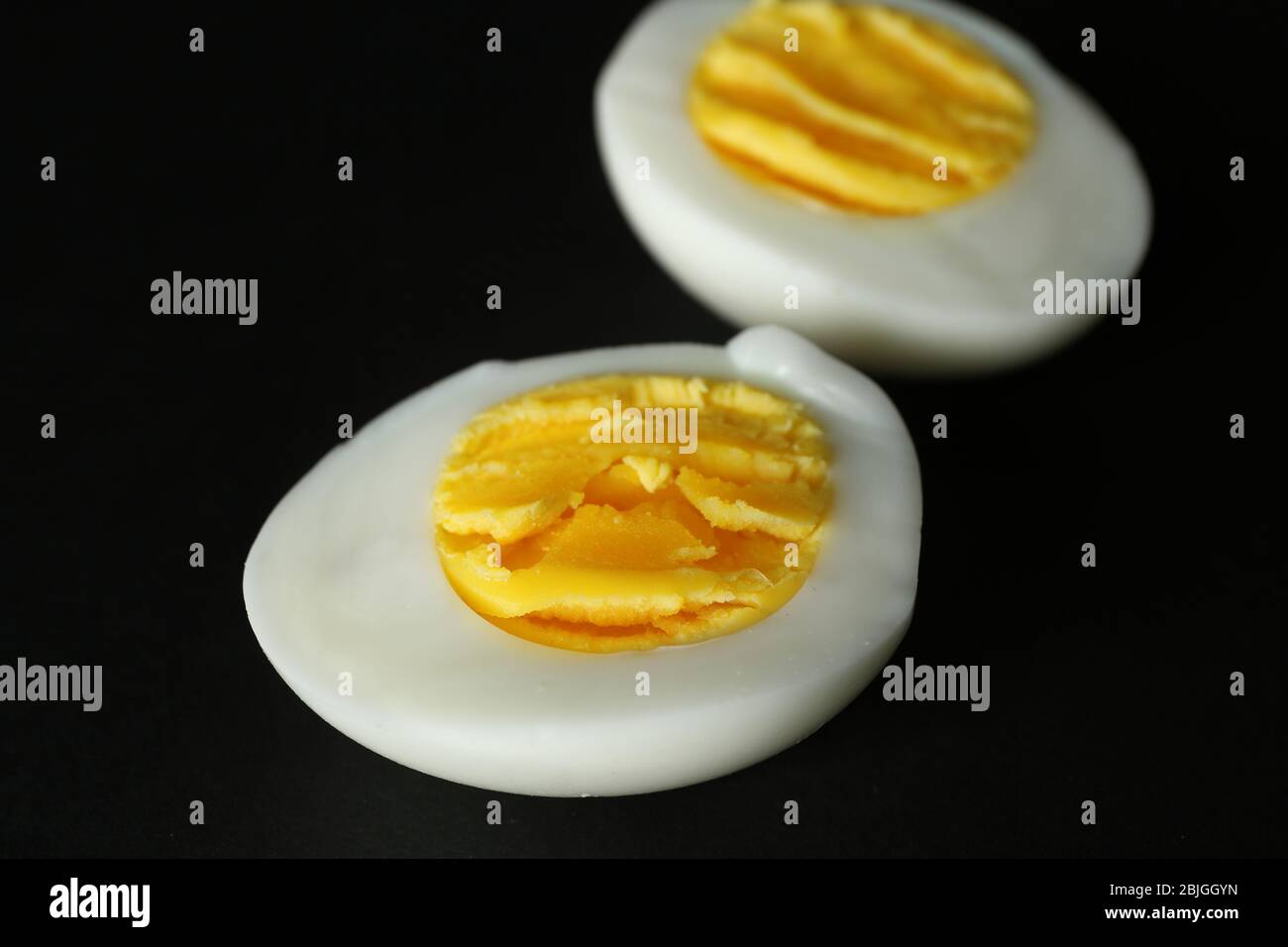 Sliced hard boiled egg on black background. Nutrition concept Stock Photo - Alamy