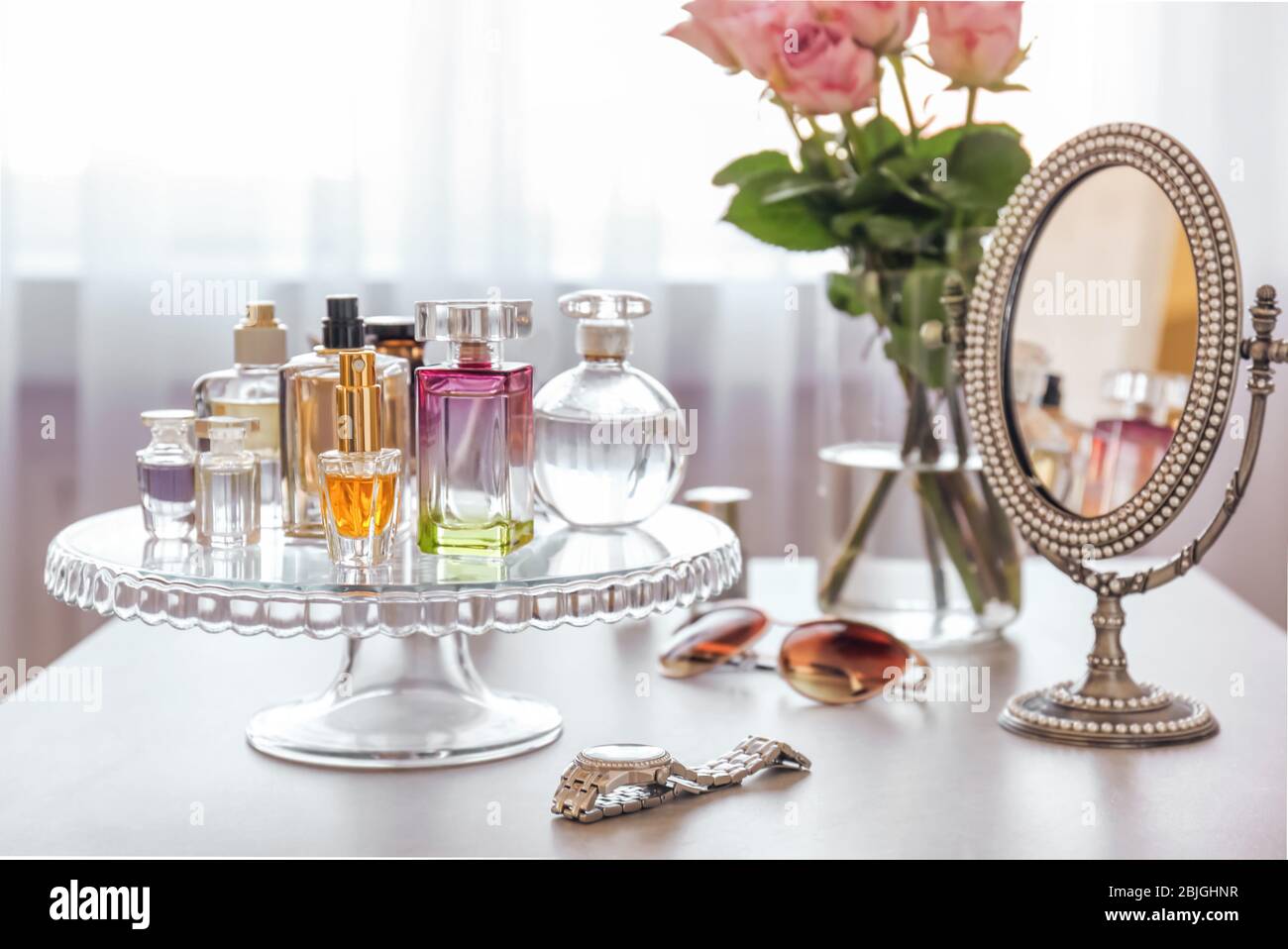 Stand with bottles of perfume on table Stock Photo - Alamy