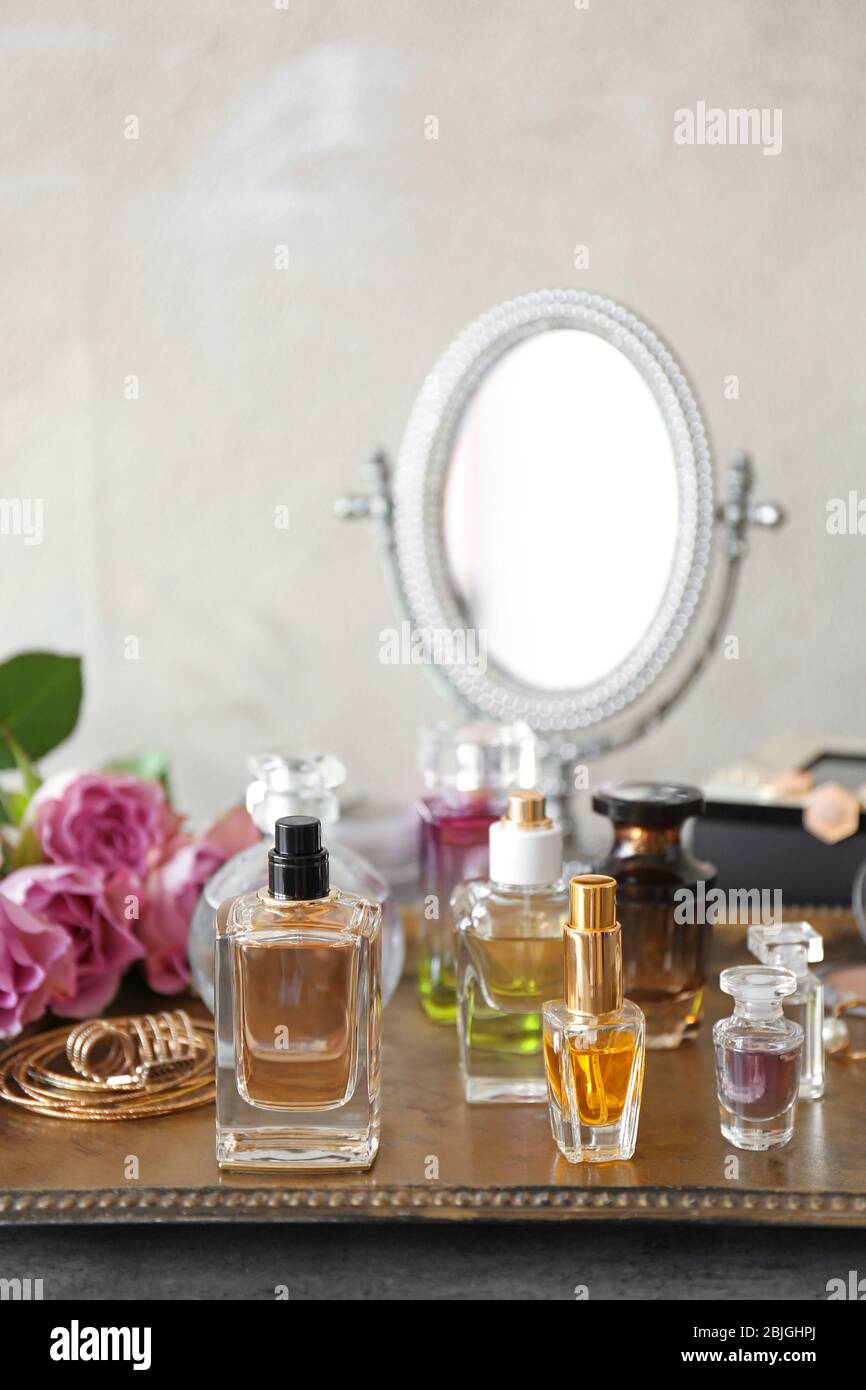 Metal tray with bottles of perfume on table Stock Photo - Alamy