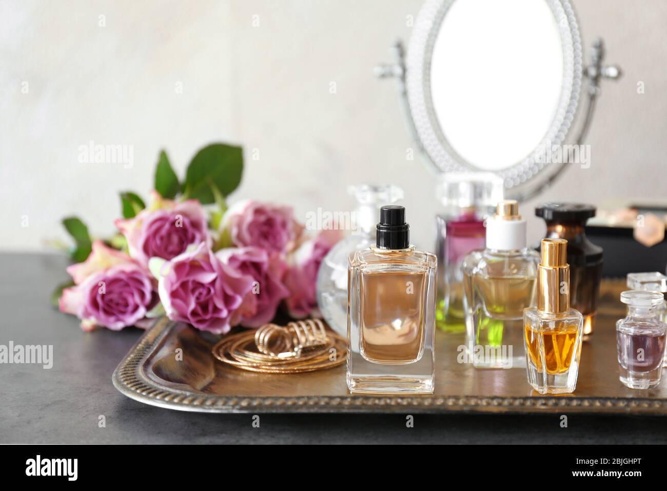 Metal tray with bottles of perfume on table Stock Photo - Alamy