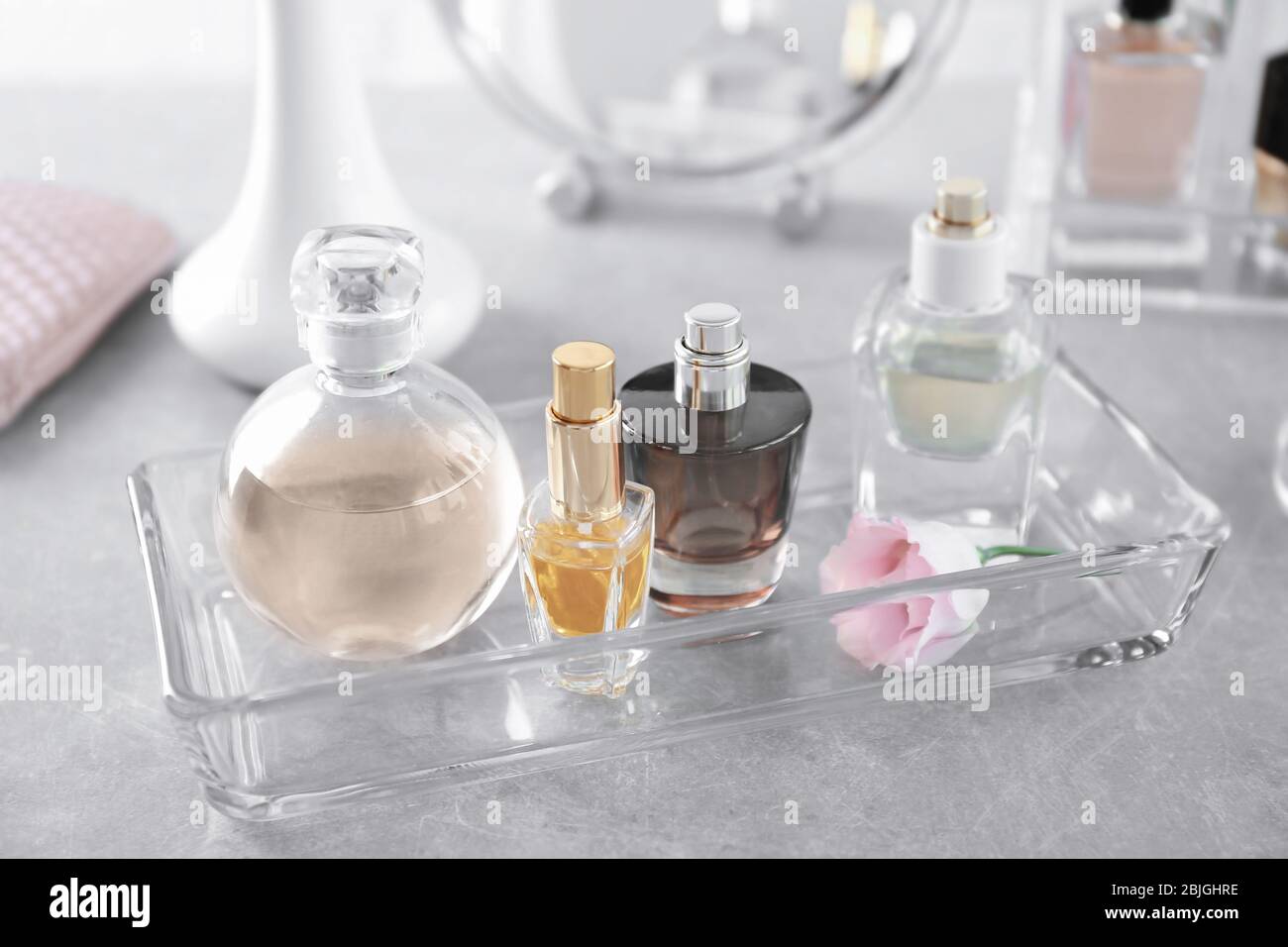 Glass tray with bottles of perfume on table Stock Photo - Alamy