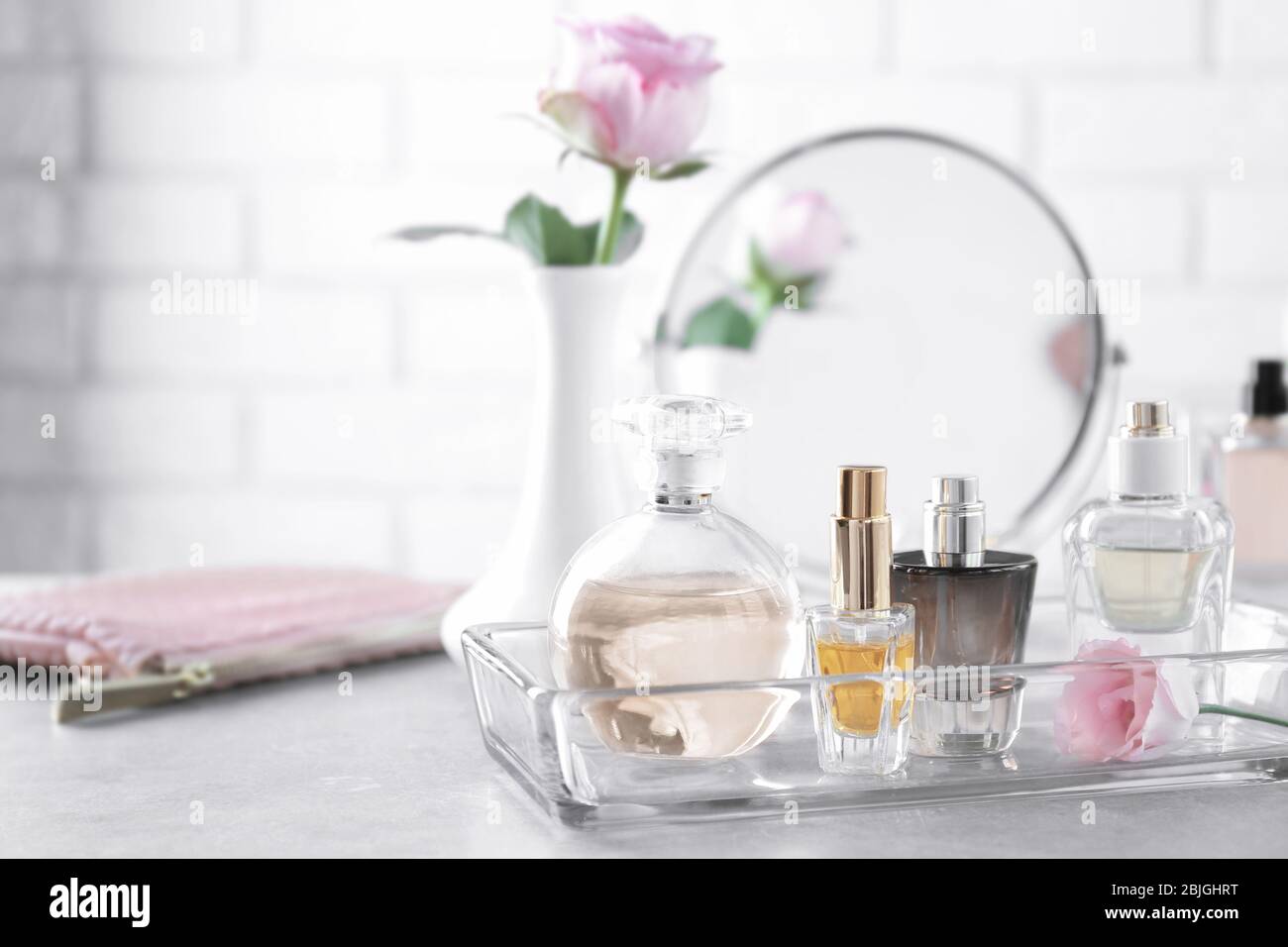 Glass tray with bottles of perfume on table Stock Photo - Alamy