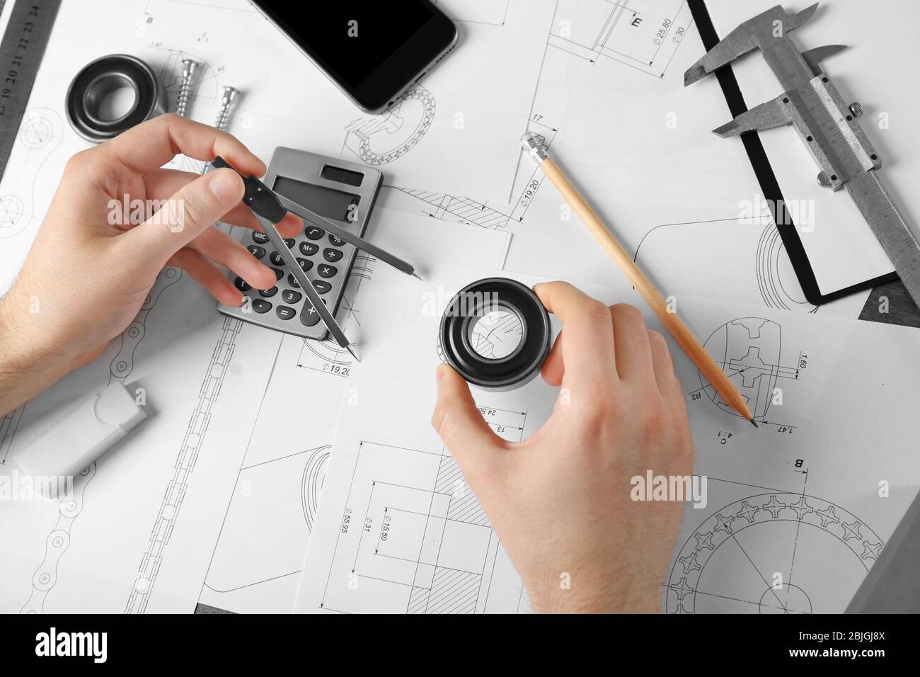Engineer working at table with drawings Stock Photo - Alamy