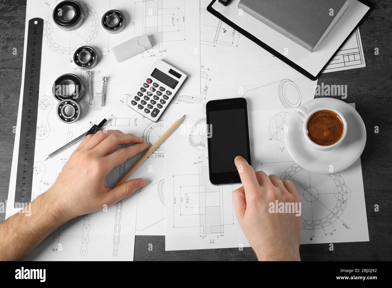 Engineer working with phone at table Stock Photo - Alamy