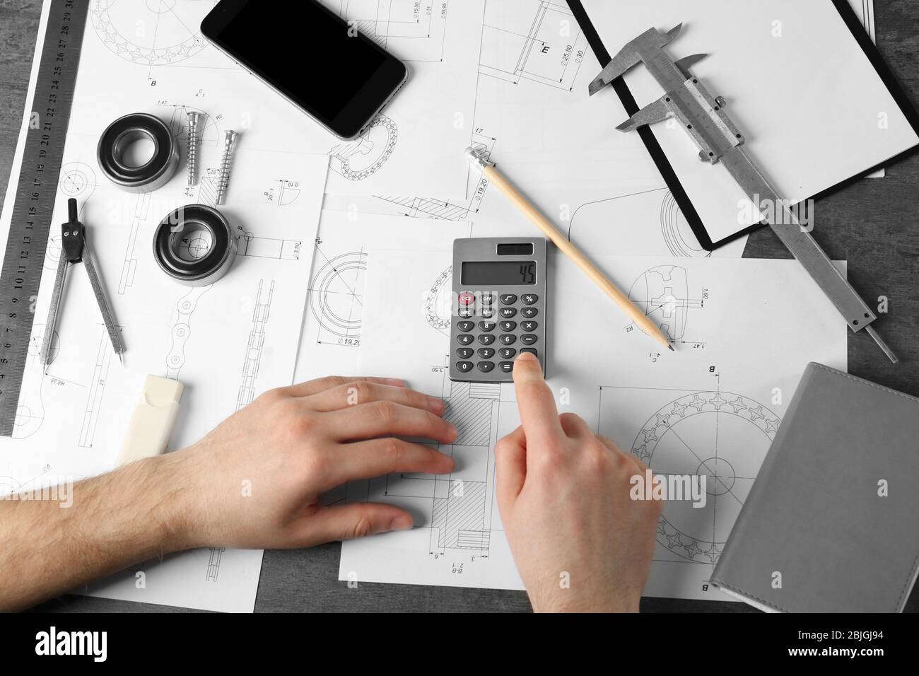Engineer working at table with drawings Stock Photo - Alamy