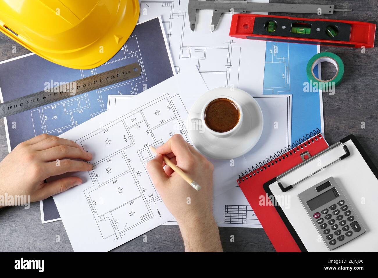 Engineer working at table with drawings Stock Photo - Alamy