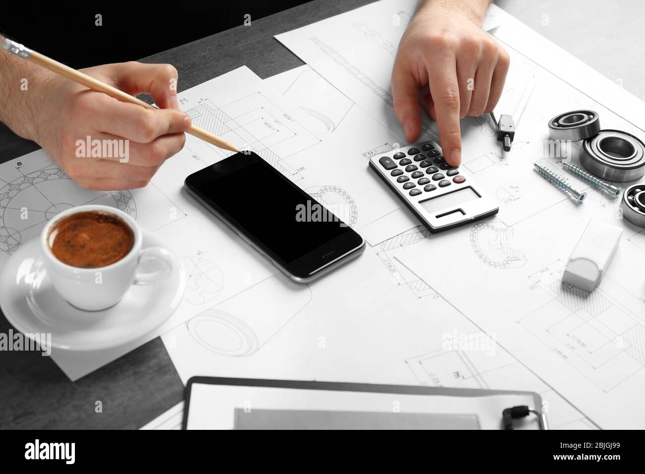 Engineer working at table with drawings Stock Photo - Alamy