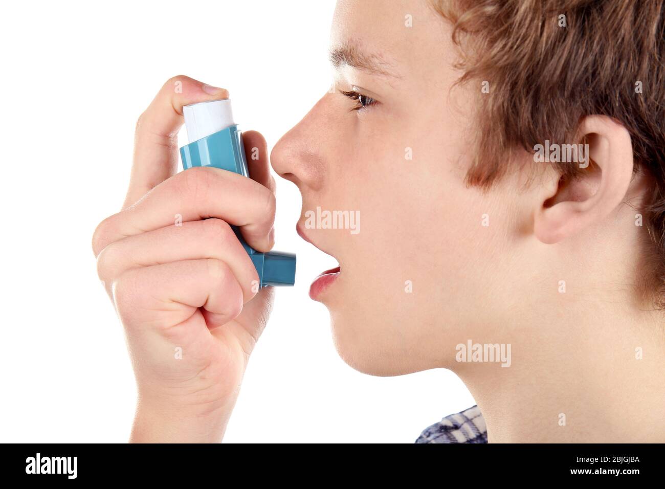Young boy using inhaler for asthma and respiratory diseases on white ...