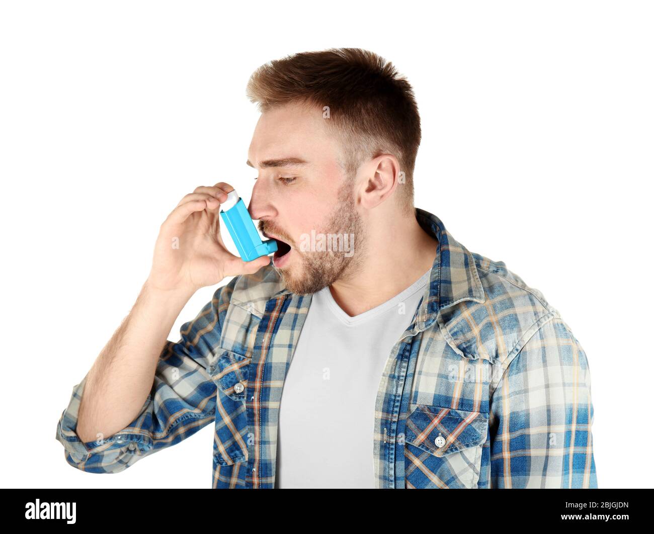 Young man using inhaler for asthma and respiratory diseases on white ...