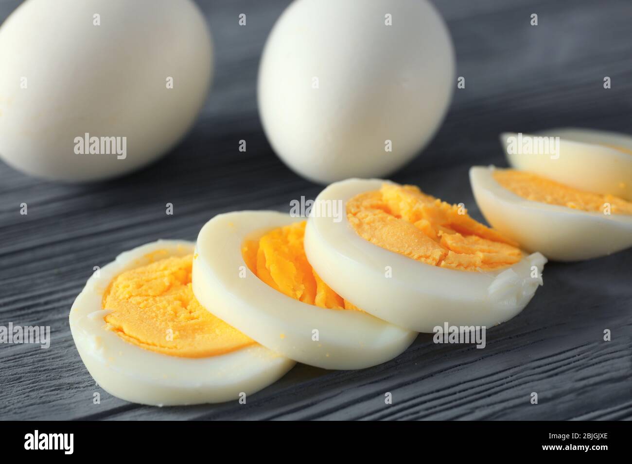 Sliced hard boiled eggs on wooden background. Nutrition concept Stock Photo - Alamy