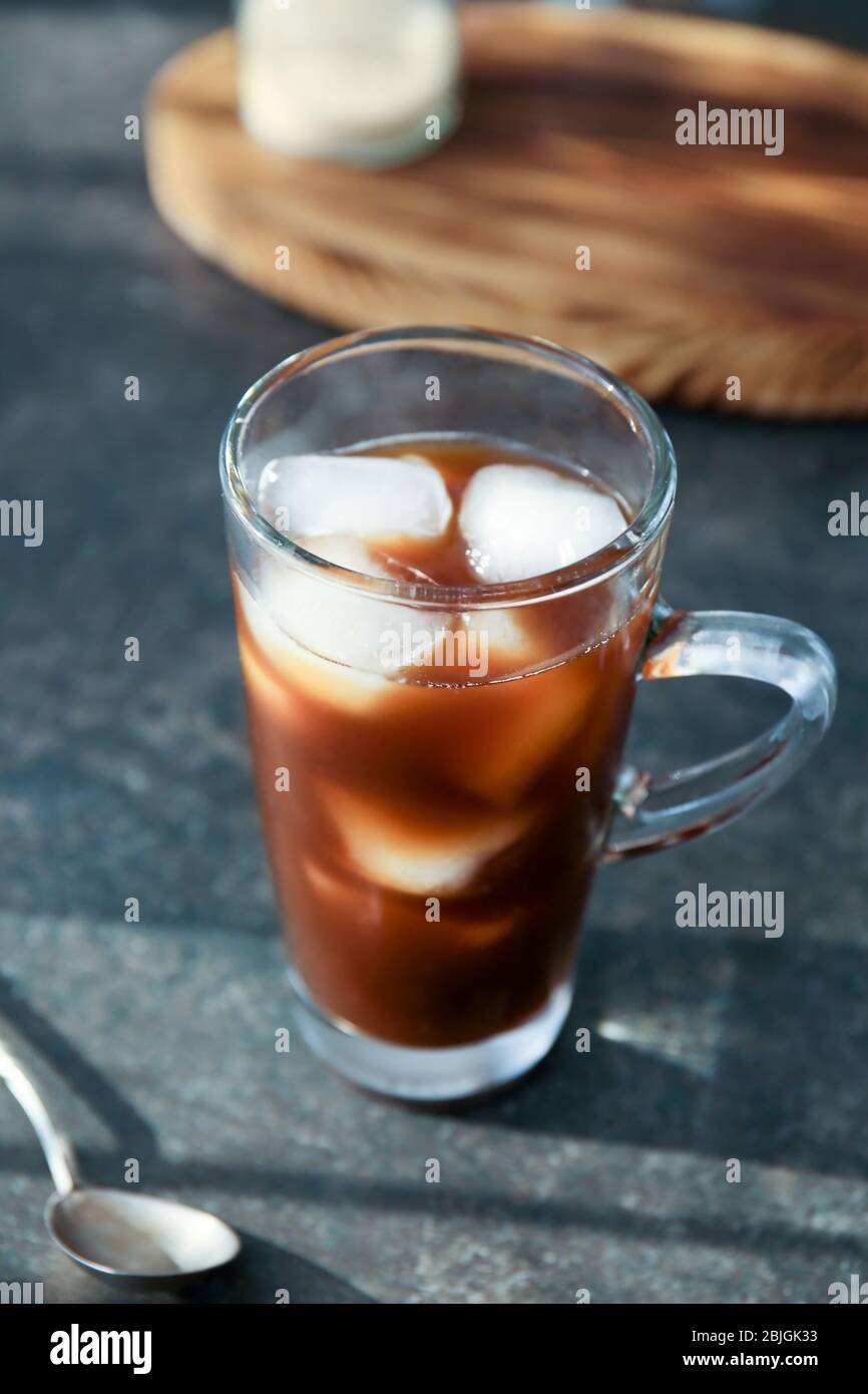 Glass cup with cold brew coffee and spoon on grey table Stock Photo - Alamy