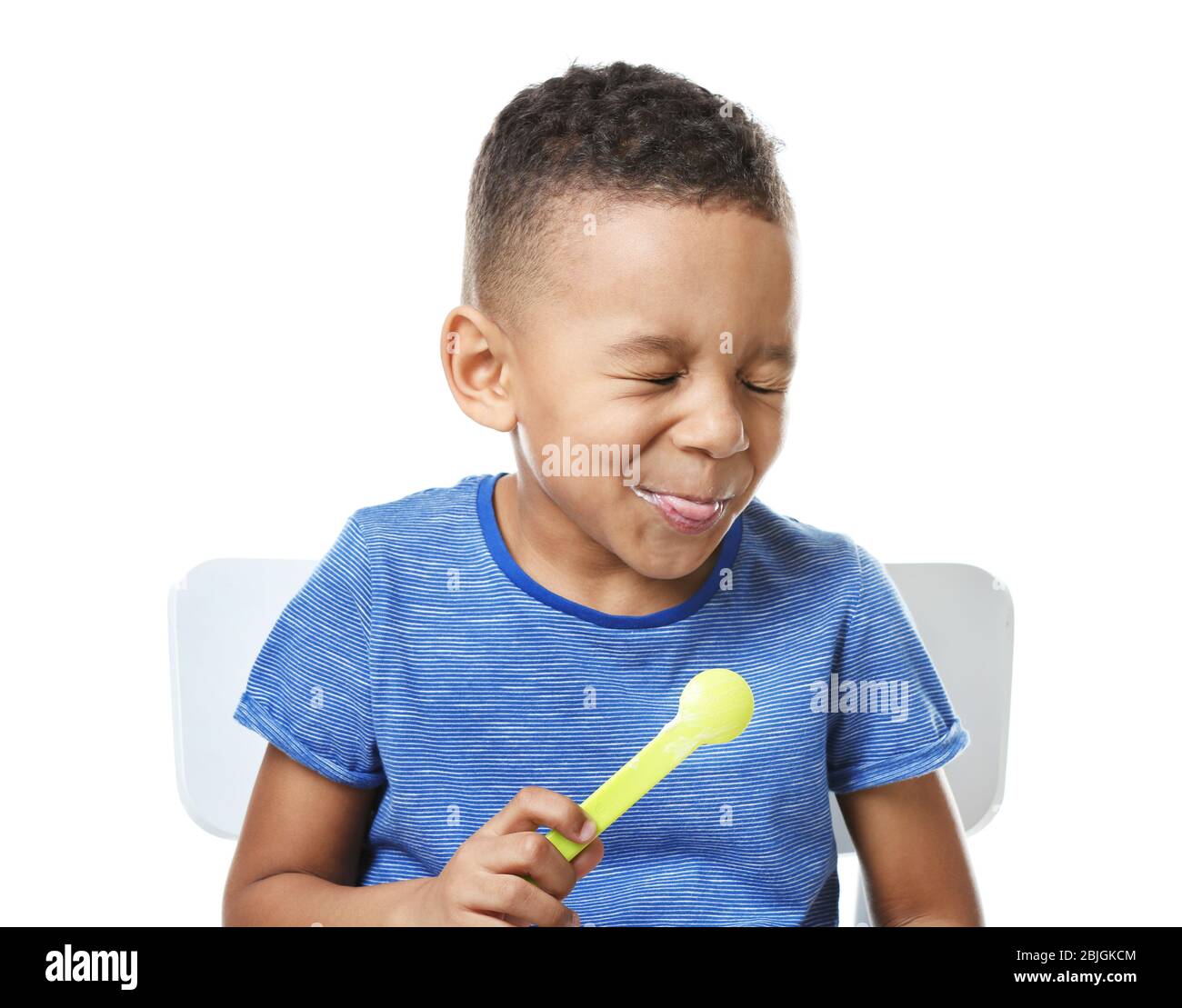 Cute African American boy eating yogurt on white background Stock Photo ...
