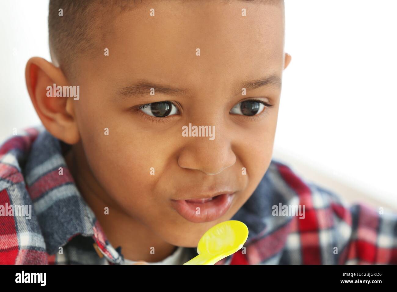 Cute African American boy eating yogurt at home, closeup Stock Photo ...