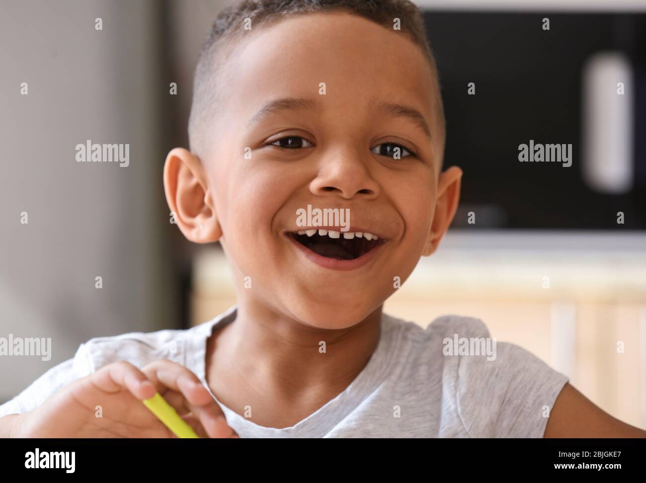 Cute African American boy eating yogurt at home Stock Photo - Alamy