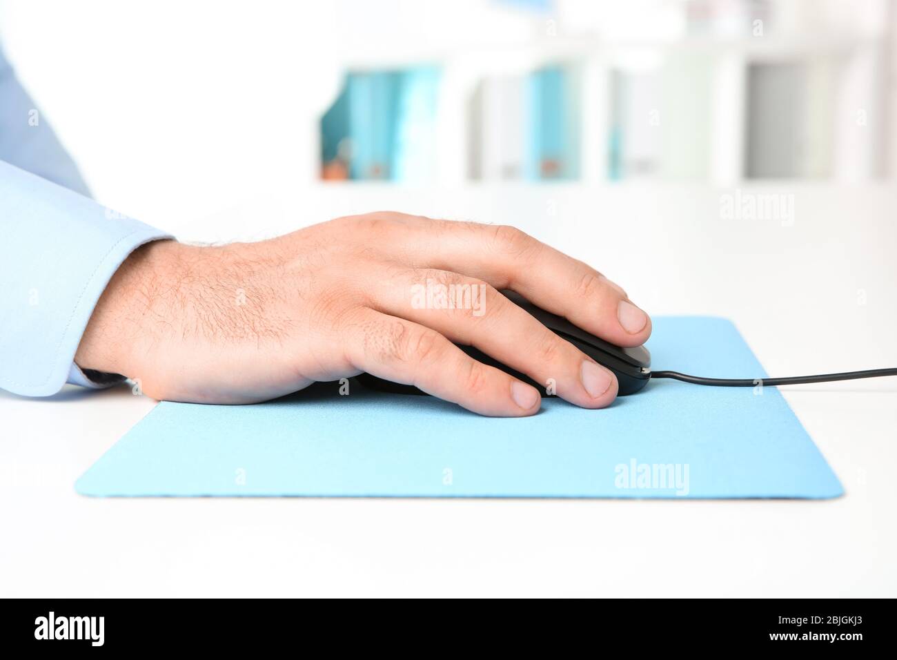 Hand of man working with computer mouse in office Stock Photo - Alamy