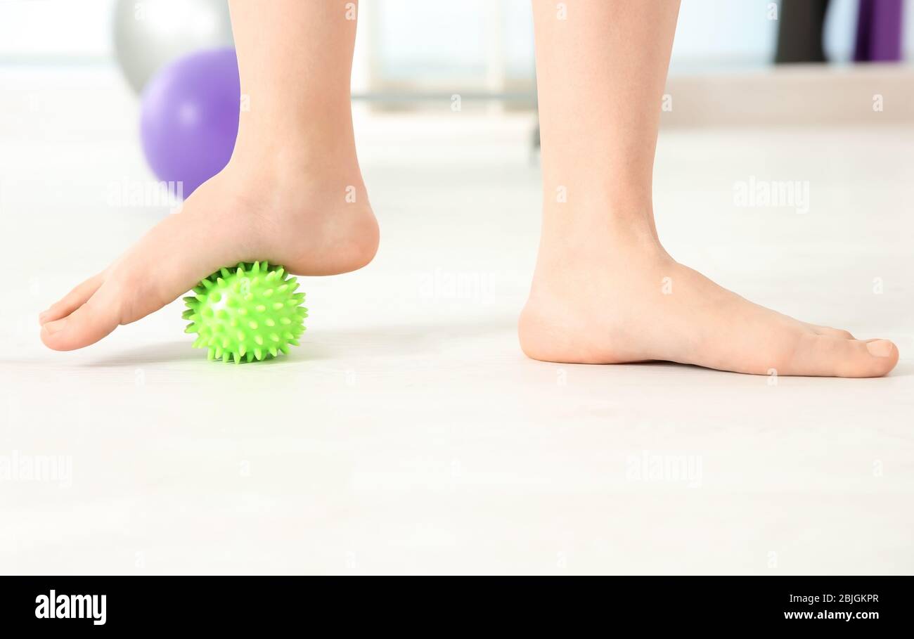Feet of woman doing exercises with rubber ball in clinic Stock Photo ...