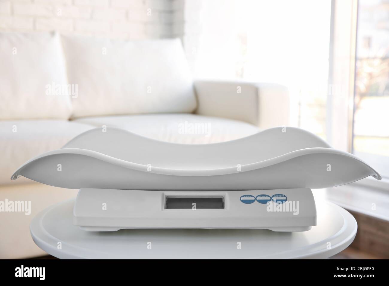 Modern baby scales on table in room Stock Photo - Alamy