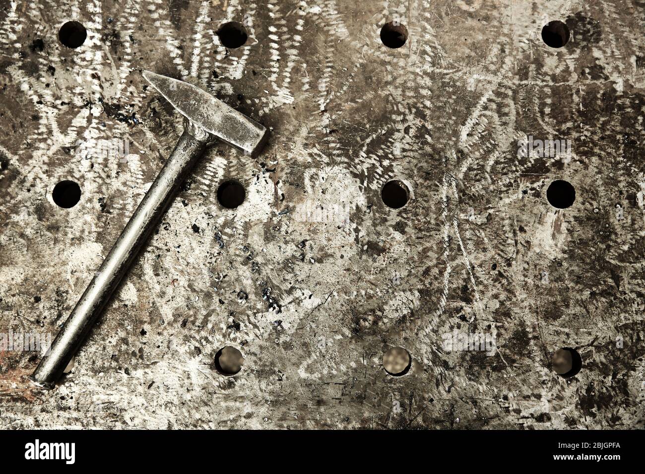 Hammer for metalworking on perforated table in shop Stock Photo - Alamy