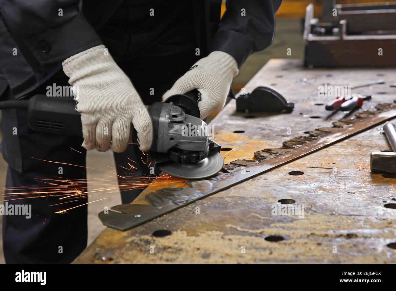 Man using angle grinder for metalworking in shop Stock Photo - Alamy