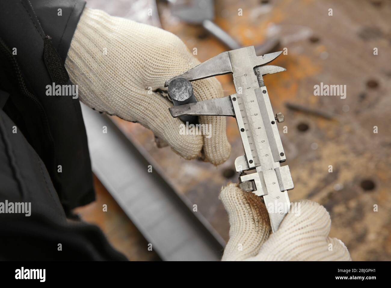 Man using vernier caliper for measuring metal bar in shop Stock Photo ...