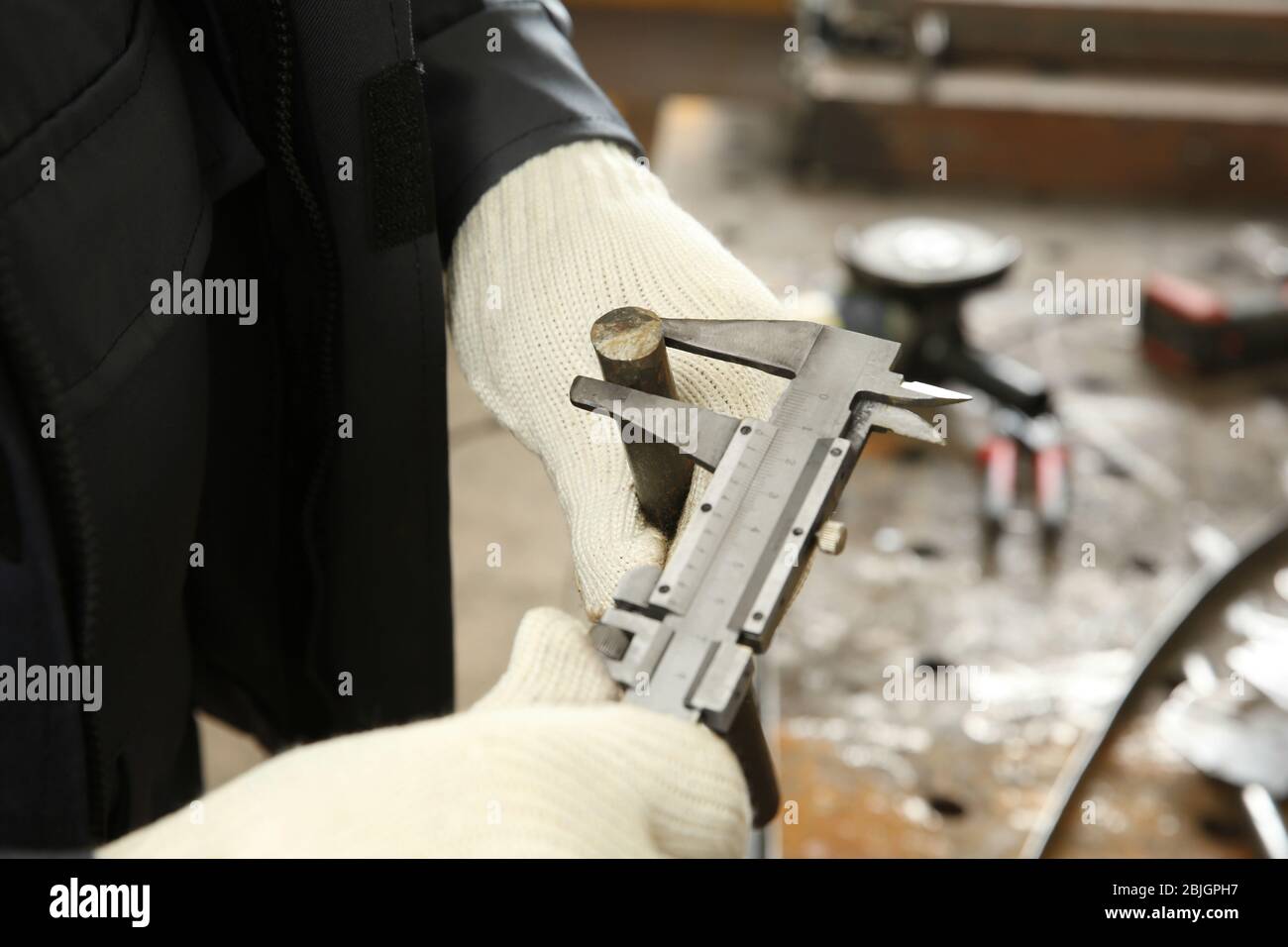 Man using vernier caliper for measuring metal bar in shop Stock Photo ...
