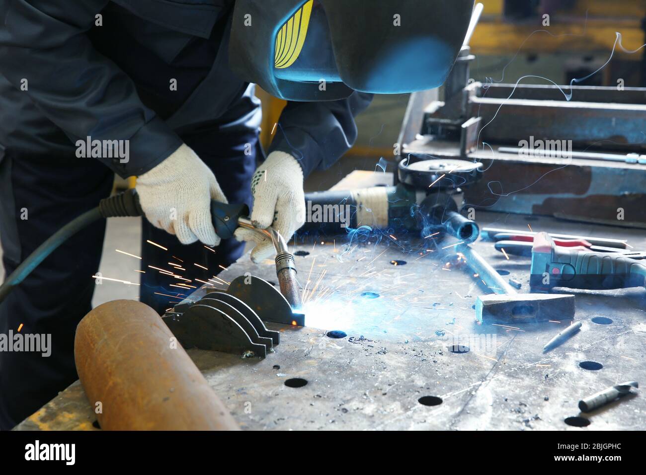 Worker using welding equipment for metalworking in shop Stock Photo - Alamy