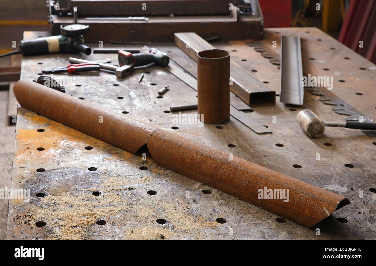 Metal bars on perforated table in workshop Stock Photo - Alamy