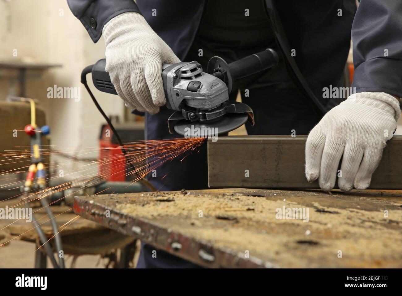 Man using angle grinder for metalworking in shop Stock Photo - Alamy